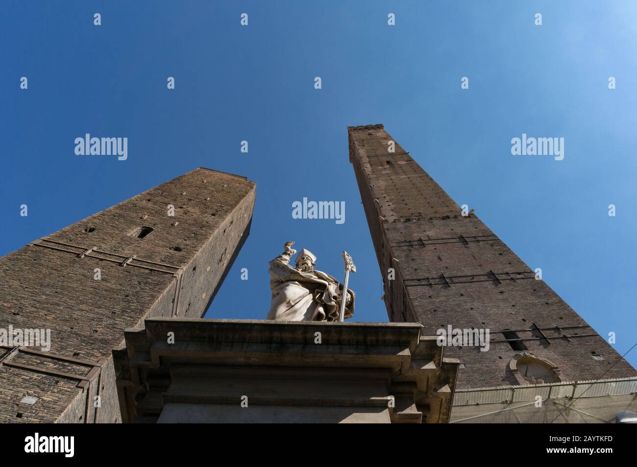 Statue of pope with hand raising for blessing with Two brick towers on ...