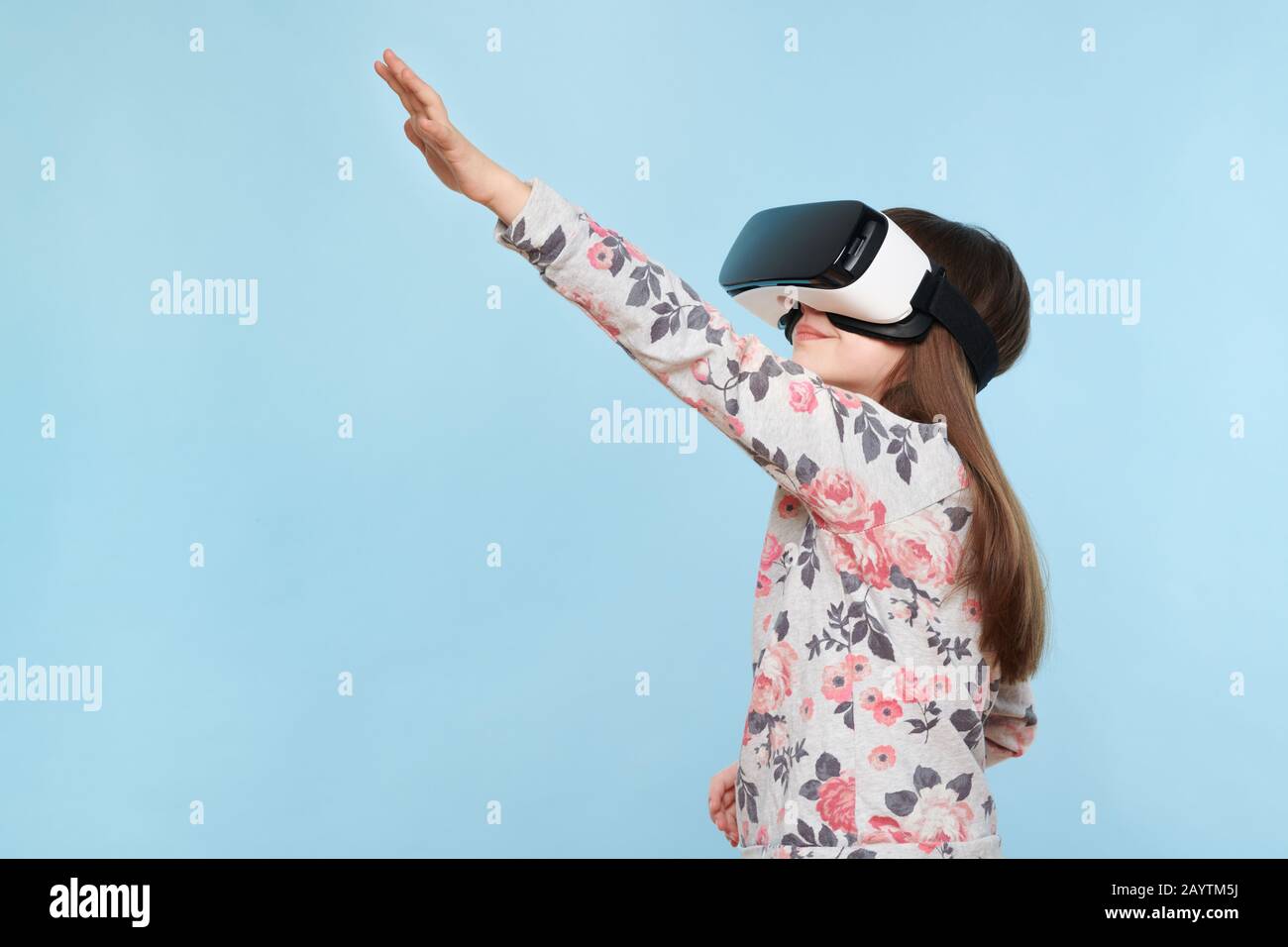 Studio portrait of cute young caucasian girl wearing virtual reality ...