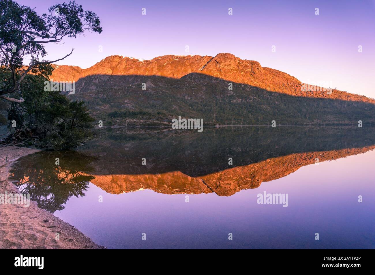 Picturesque nature background with sunlit mountains and lake at sunrise ...