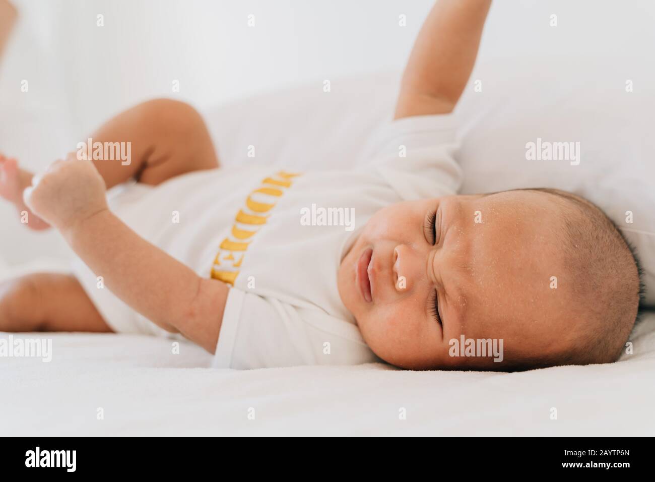 Sad small Asian infant in pajama with closed eyes crying newborn baby ...