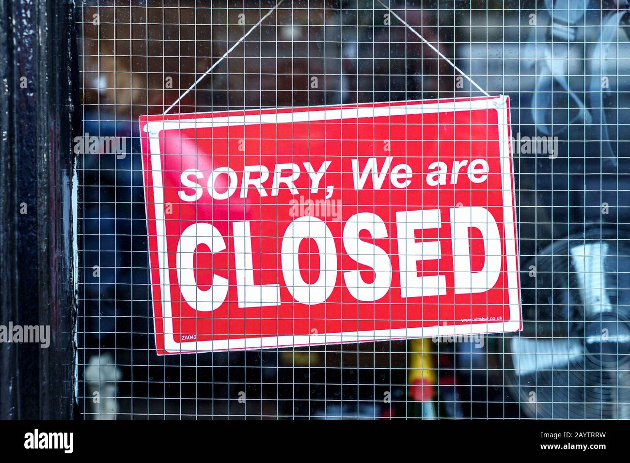 Sorry we are closed sign in shop window with wire mesh Stock Photo - Alamy