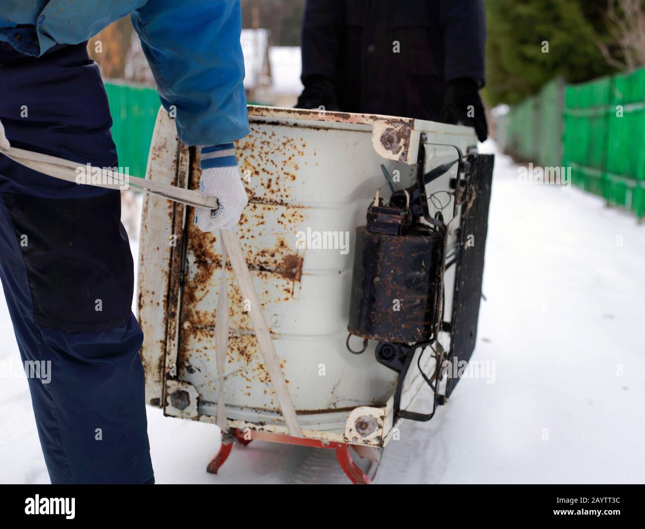 People pulling the sled loaded with old fridge, winter scene Stock ...