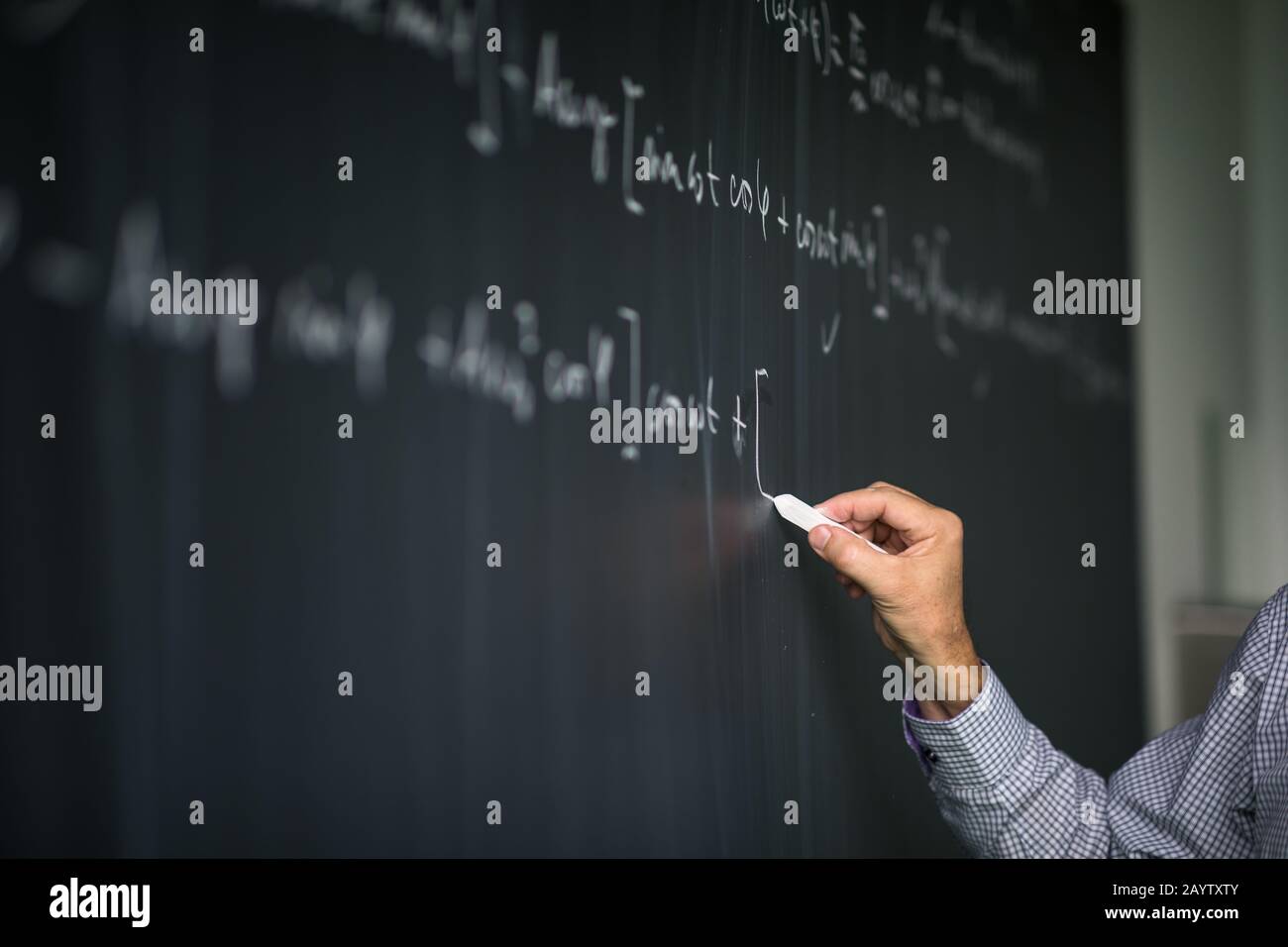 Math teacher by the blackboard during mathclass - detail of the hand ...