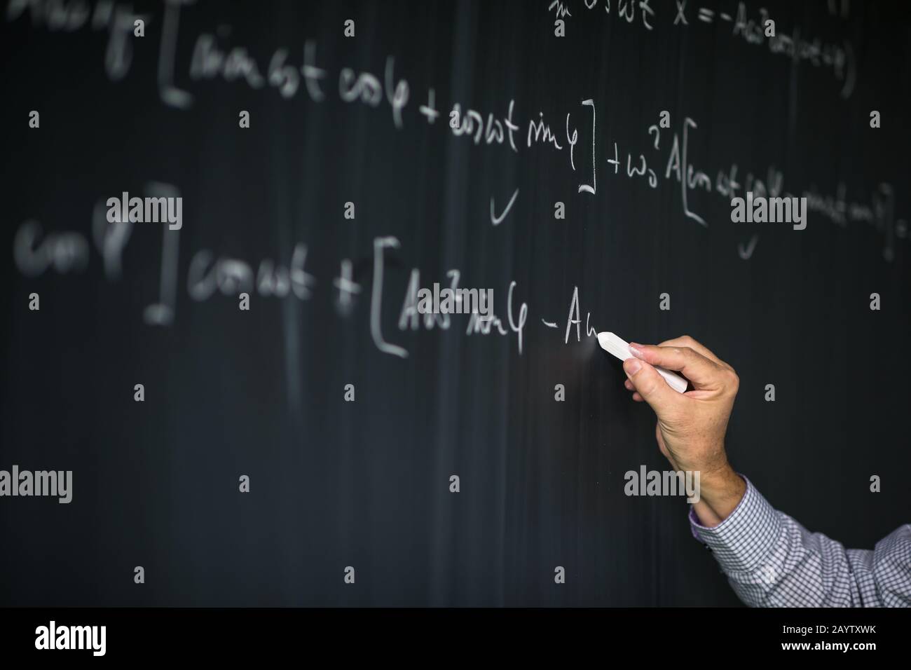 Math teacher by the blackboard during mathclass - detail of the hand ...