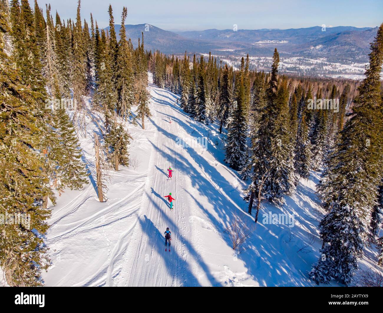 Group of friends snowboarders and skiers rides along track through ...