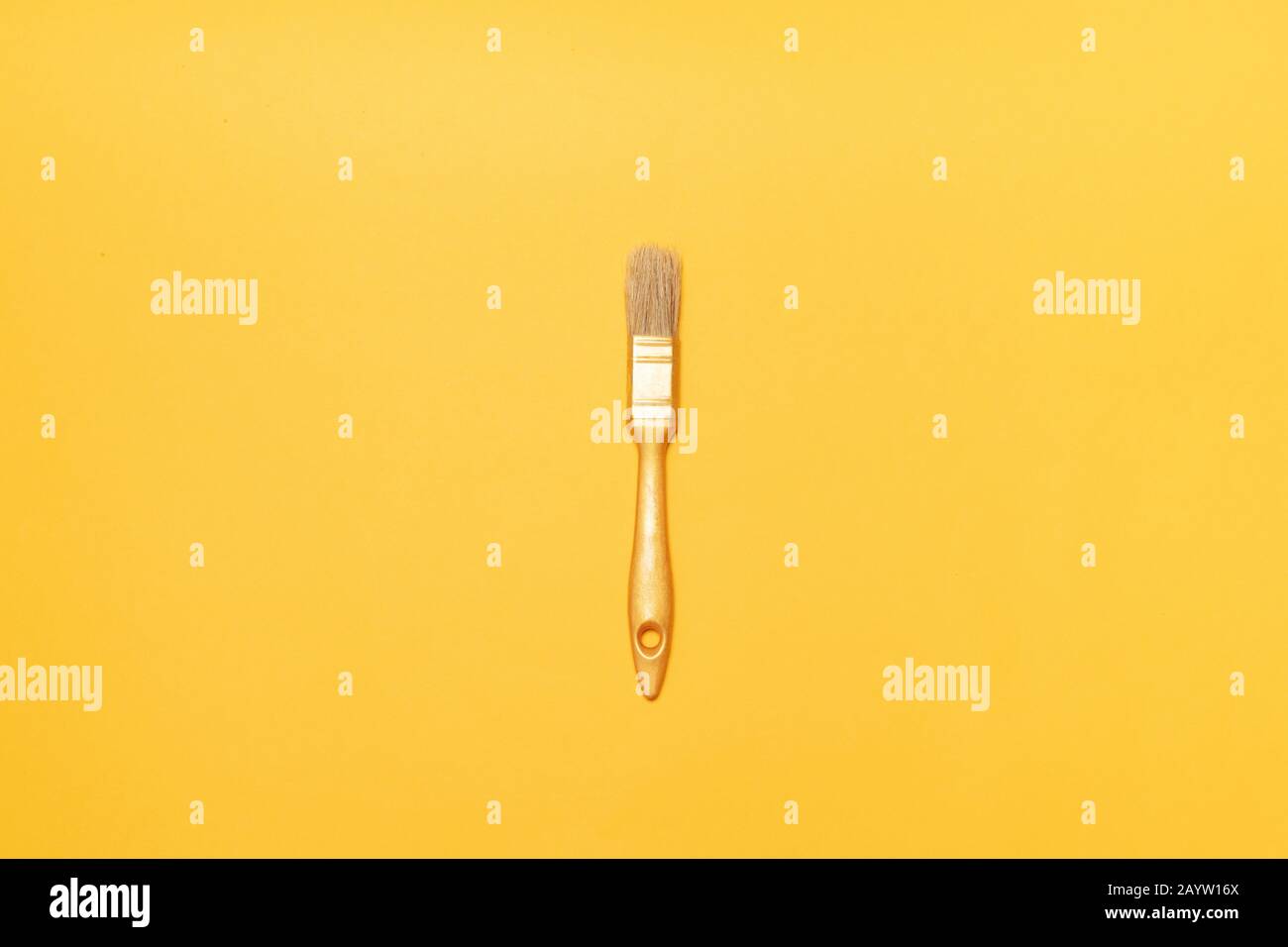 Gold paint brush on a yellow background. Minimal composition Stock ...