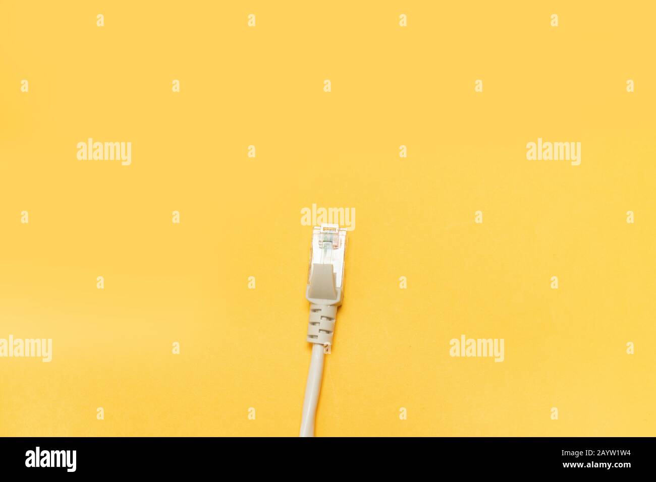Grey network cable with connectors RJ45 on a yellow background, top ...