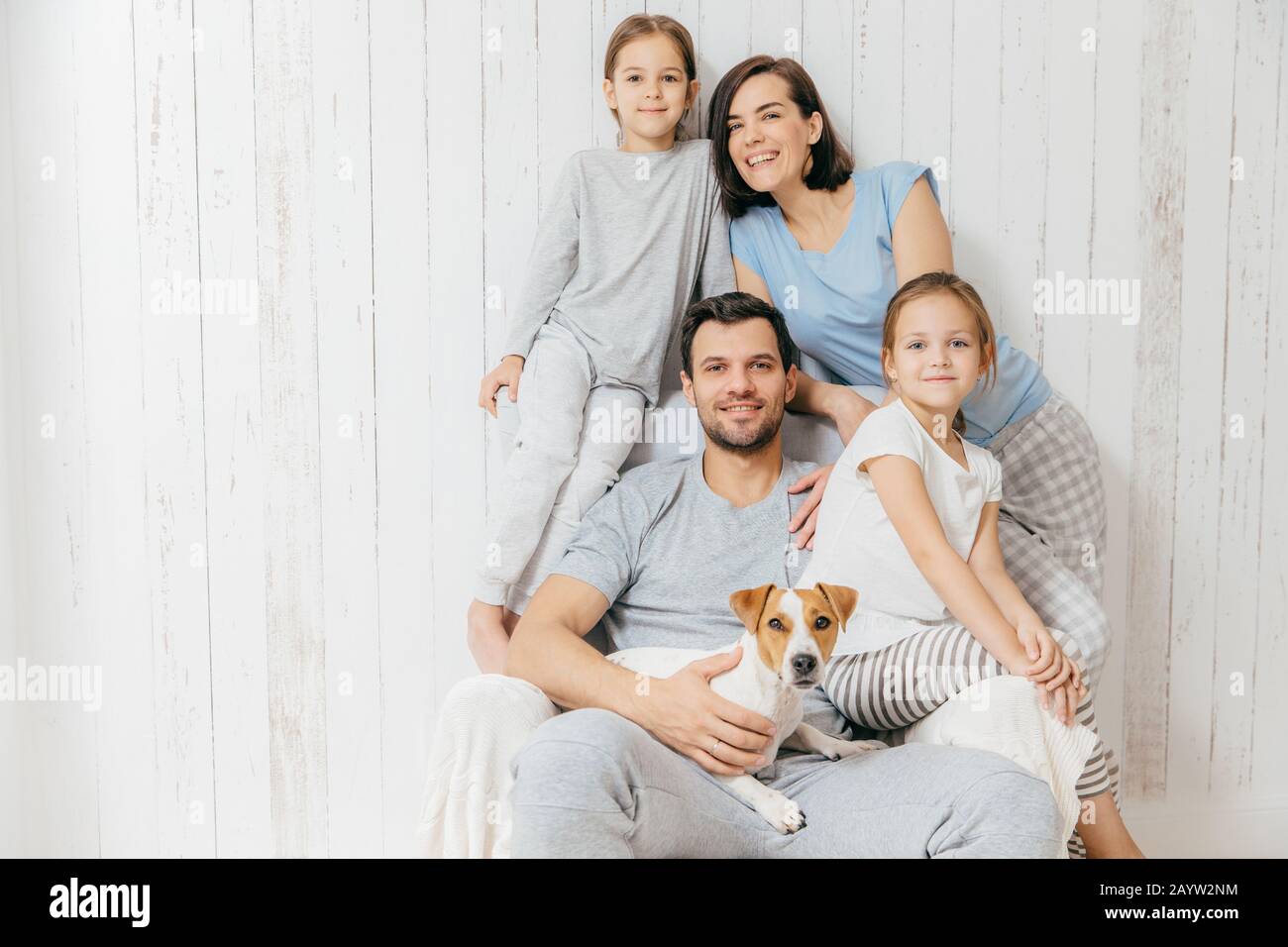 Horizontal shot of friendly family pose together against white ...