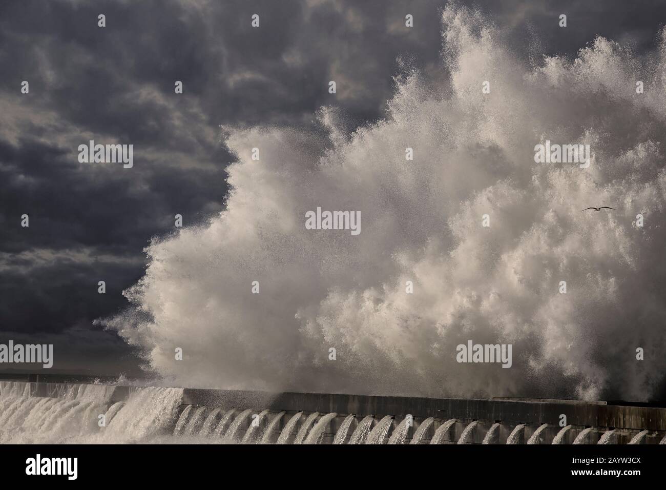 Big wave splash against dark enhanced sky Stock Photo - Alamy
