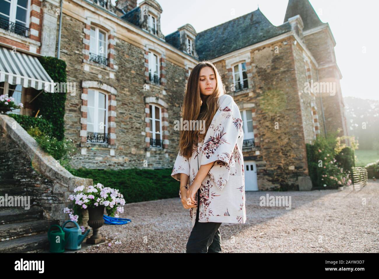 Sideways portrait of fashionable attractive young female with long hair ...