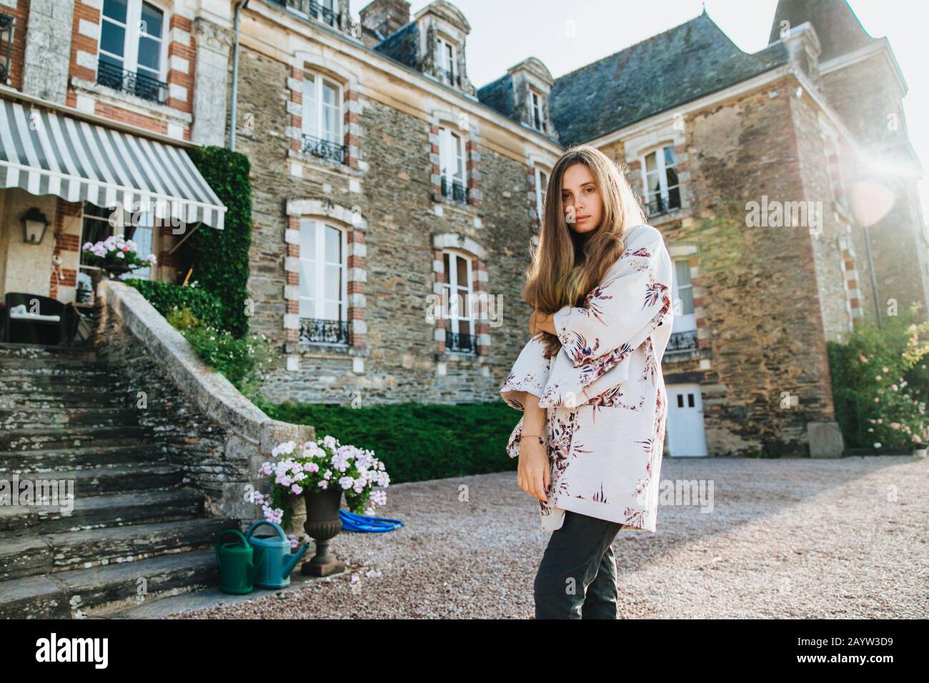 Good looking serious female model wears cape, poses against ancient ...