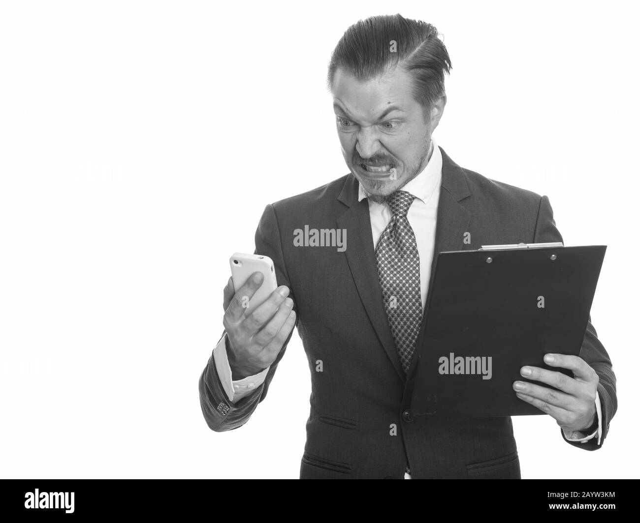 Stressed young man with mustache looking angry while using phone Stock ...