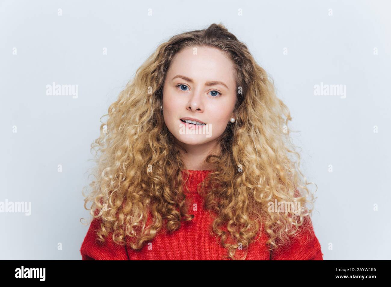 Satisfied Adorable Blue Eyed Female With Curly Light Hair Wears Red
