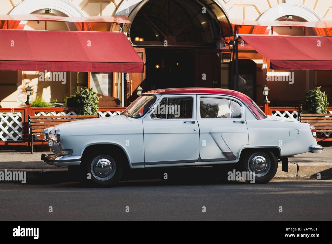 Oudoor shot of retro white car stands at asphalt against cafe ...