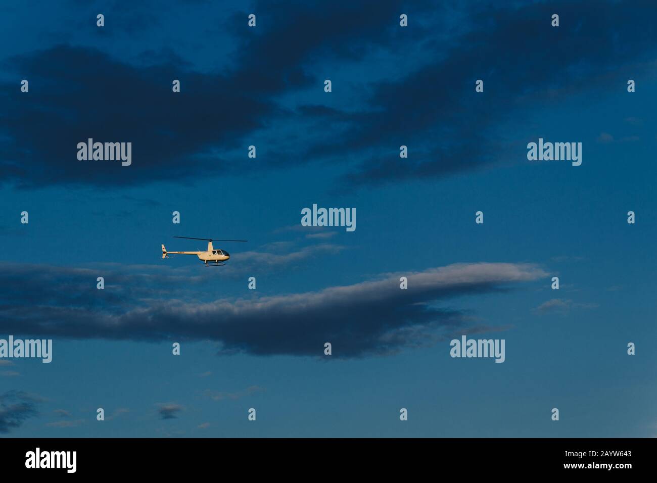 Horizontal view of small helicopter in blue sky flies very high. Small ...