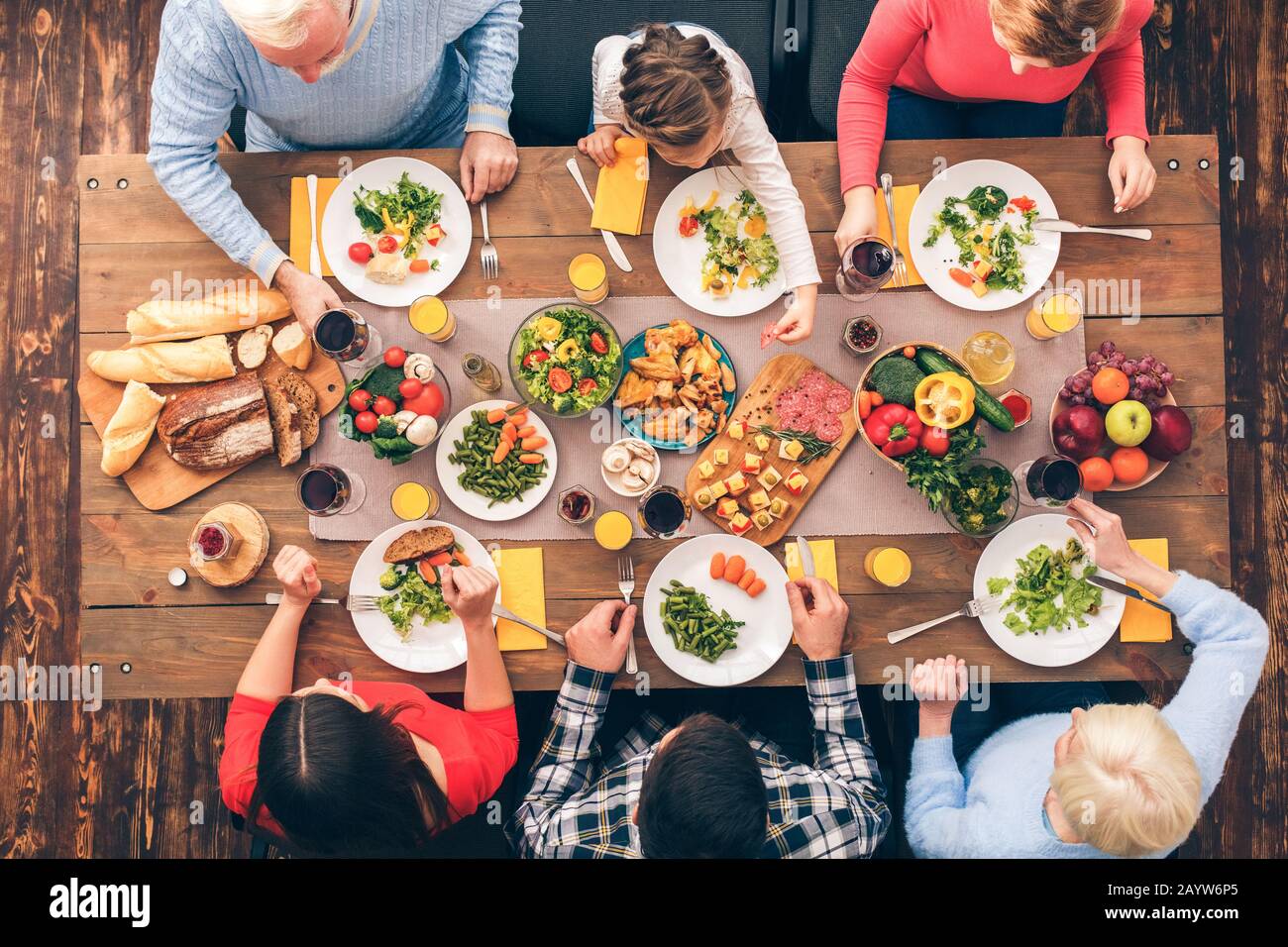 Big family, parents and young couple sit and eating Stock Photo - Alamy