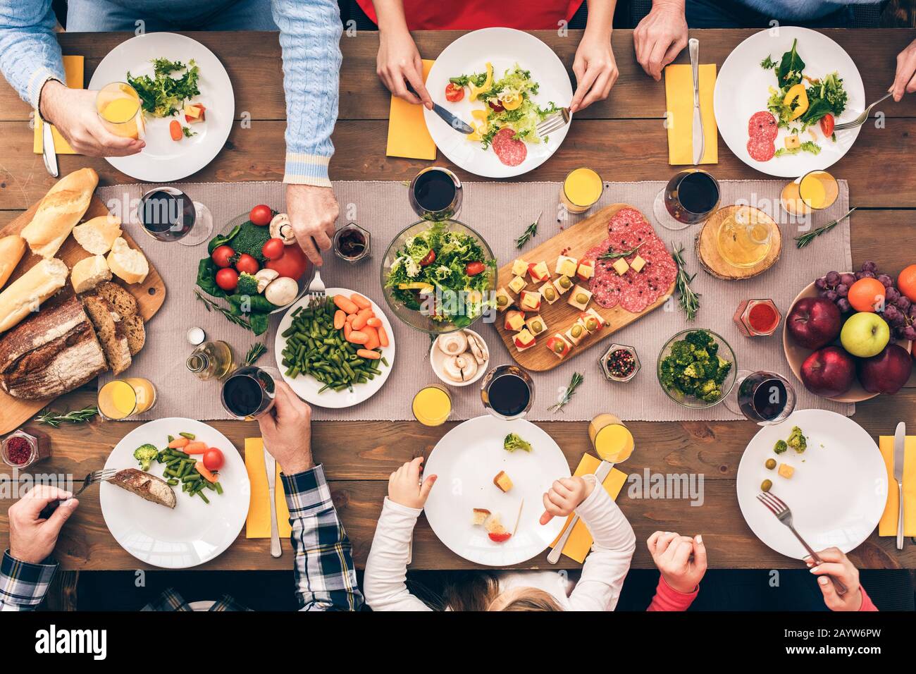 Happy family sitting at home behind table, eating tasty food Stock ...