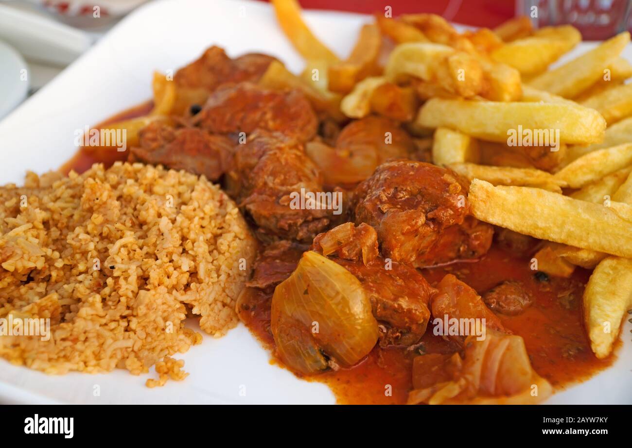 Traditional Greek Beef Stifado with rice and french fries Stock Photo ...