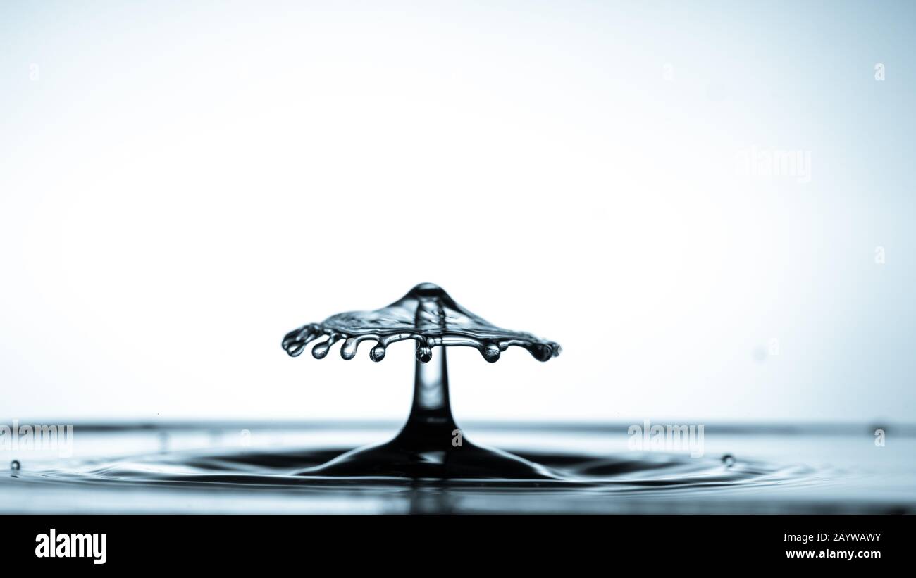 Close-up of a water drop falling on water surface Stock Photo - Alamy
