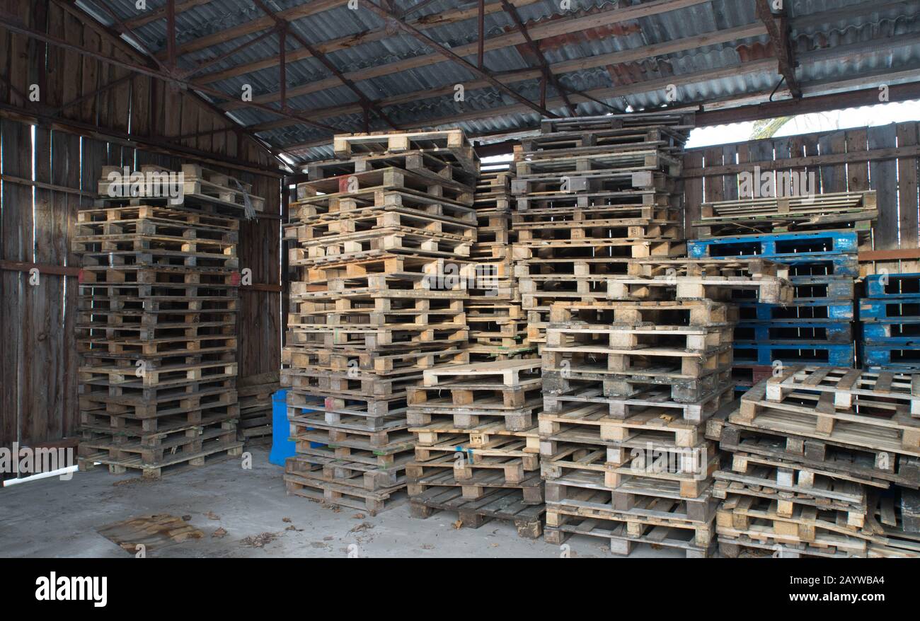 Wooden pallets stacked on top of each other inside the warehouse ...