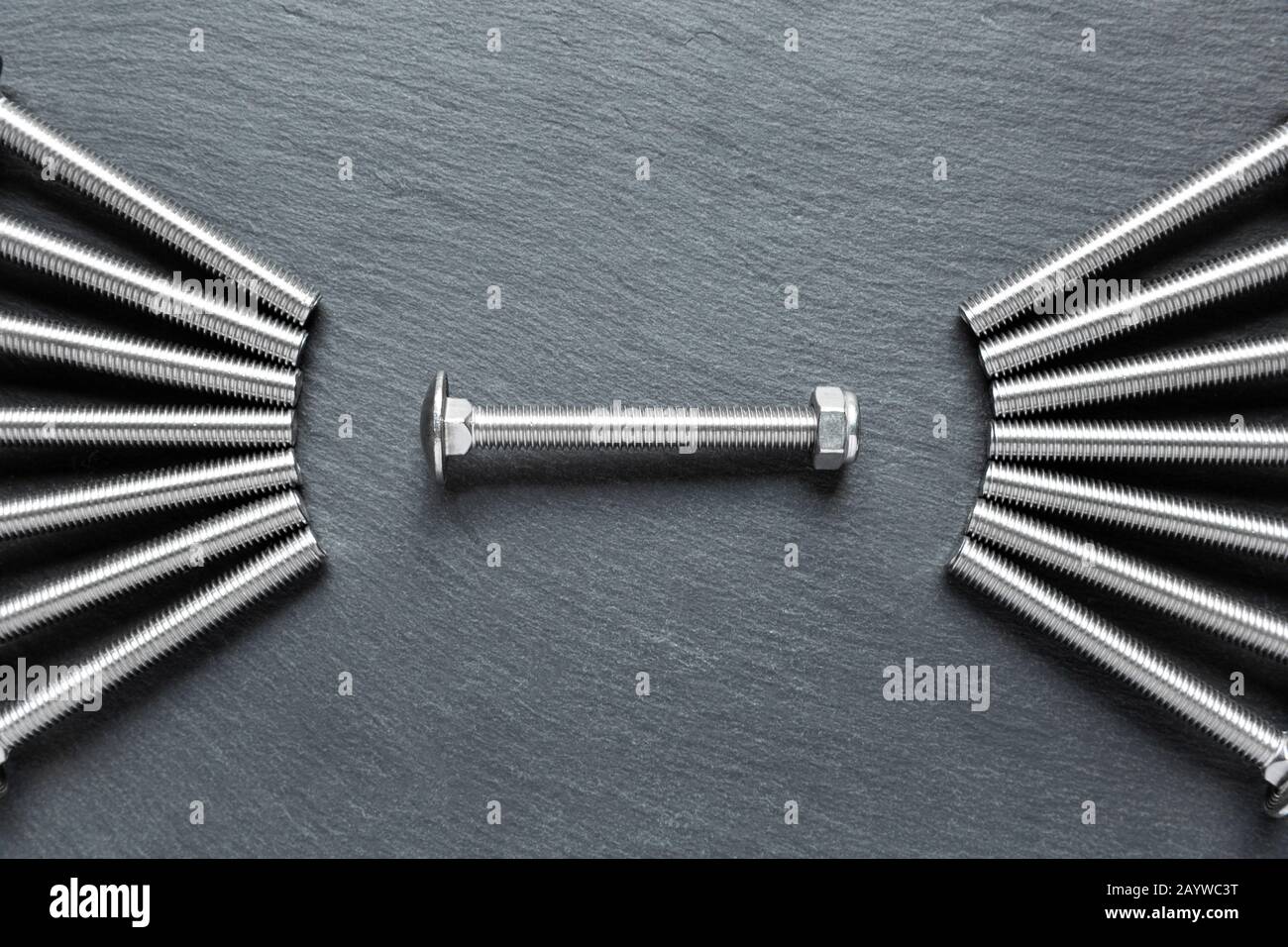 Stainless steel wood screws on a black texture background in a natural ...