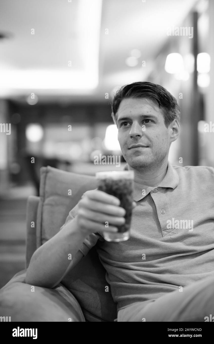 Young handsome man relaxing at the hotel lobby Stock Photo - Alamy