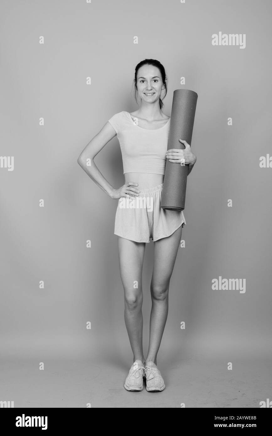 Young beautiful woman ready for gym against gray background Stock Photo ...