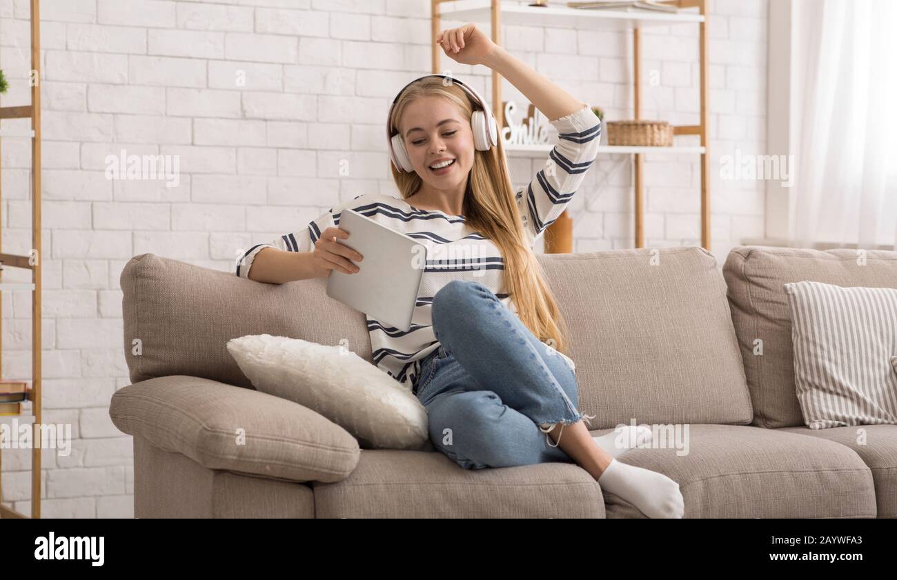Emotional girl with wireless headset holding digital tablet Stock Photo ...
