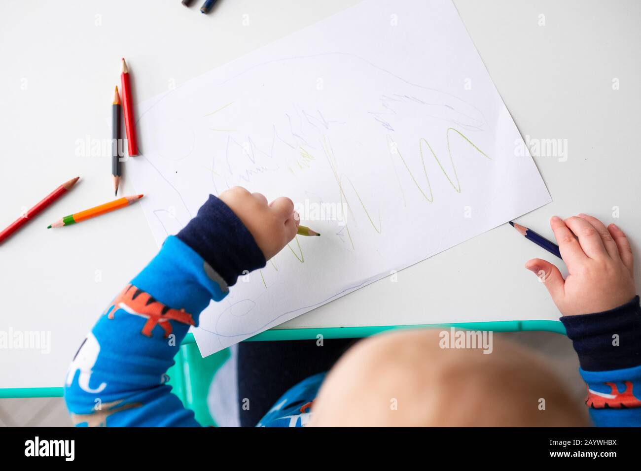 Left handed baby boy drawing a picture with colored pencils Stock Photo ...