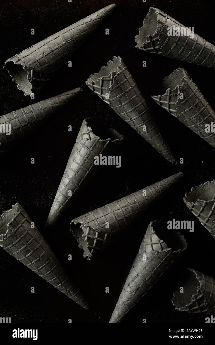 Creative monochromatic grey wafer ice cream cones or cornets scattered ...