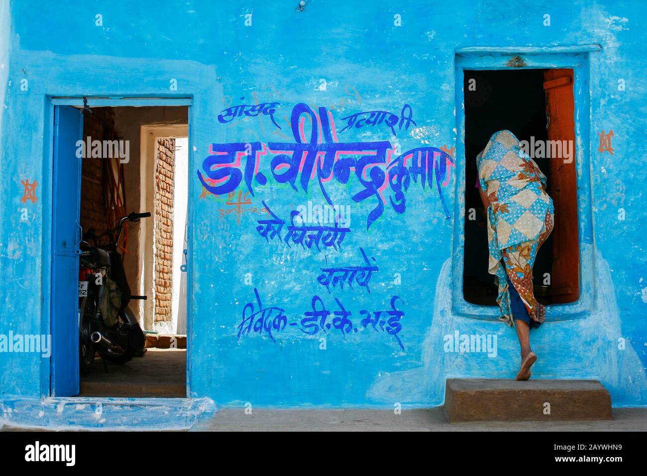 traditional Indian woman walking into her painted home Stock Photo - Alamy