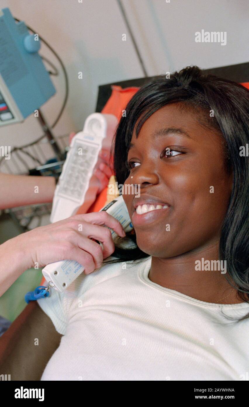 Woman having her temperature checked with a digital ear thermometer Stock Photo - Alamy
