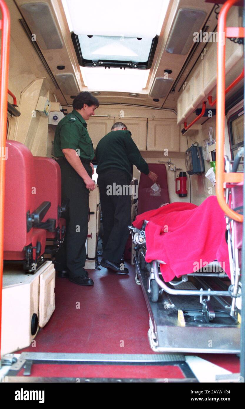 Two paramedics attend to a patient in the back of an ambulance Stock ...
