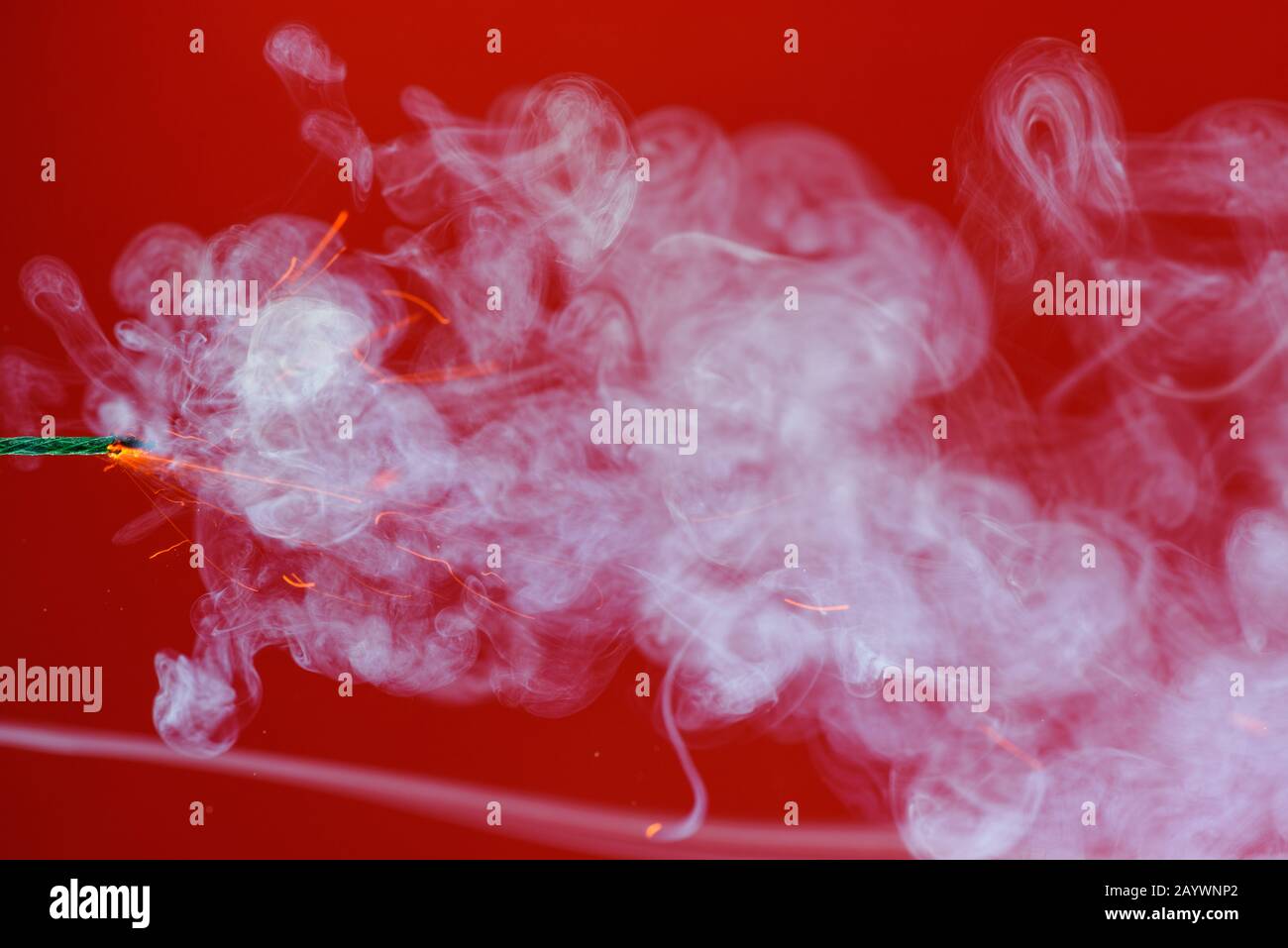Fuse wick cord burning with sparks and smoke on red background Stock ...
