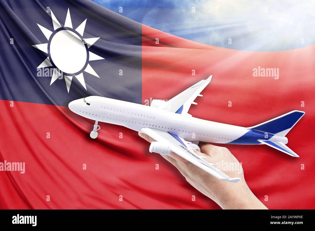 Airplane in hand with national flag of Taiwan on a background of blue ...