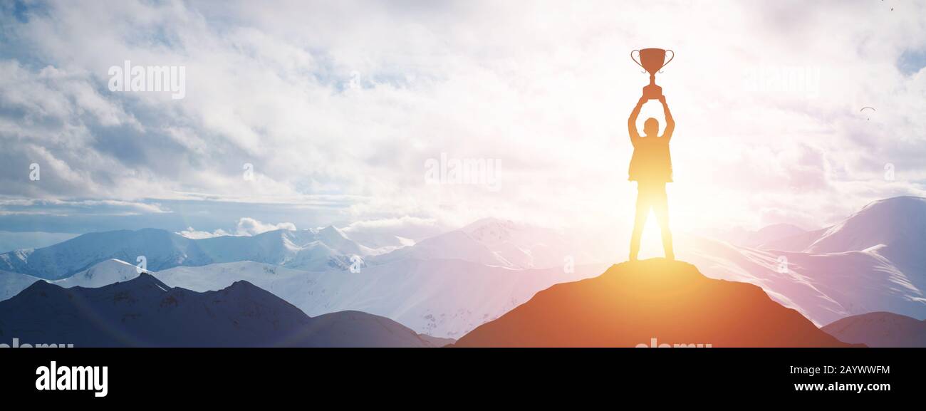 Silhouette of a man holding a trophy at sunset. Success concept Stock ...