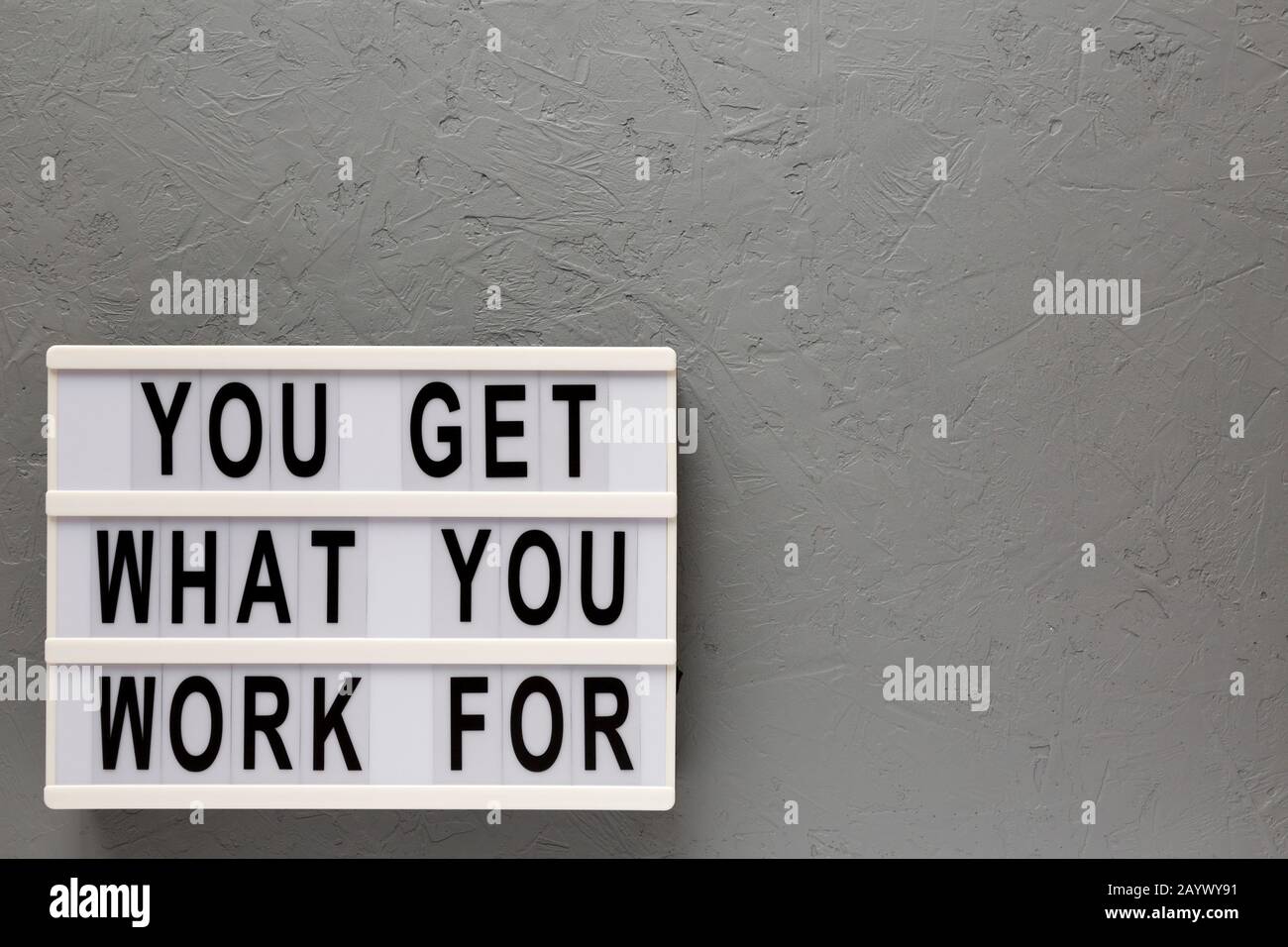 'You get what you work for' words on a lightbox on a gray surface, top ...