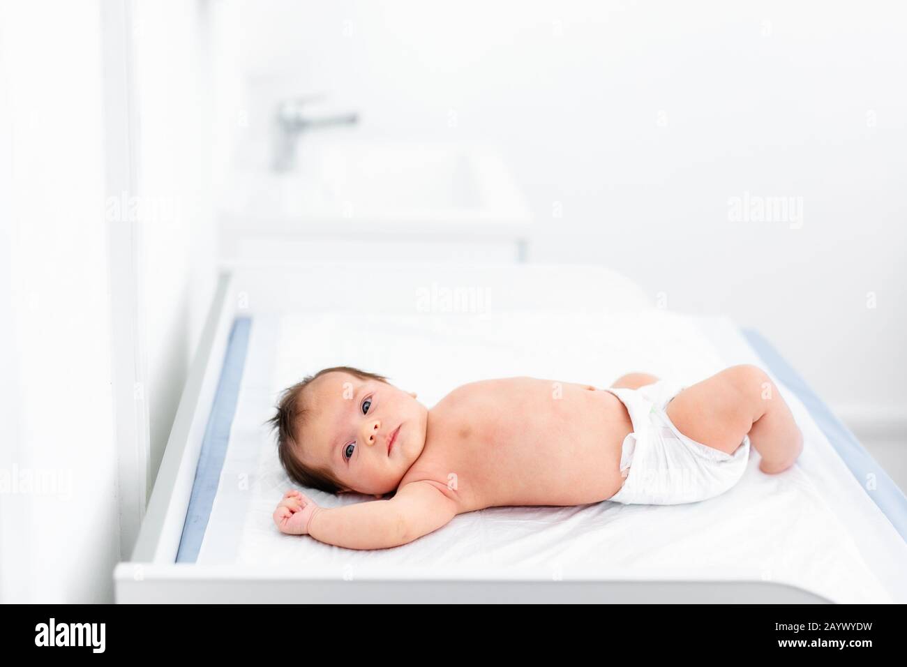 Doctor hand hold tiny Asian newborn baby sick sleeping during examine ...