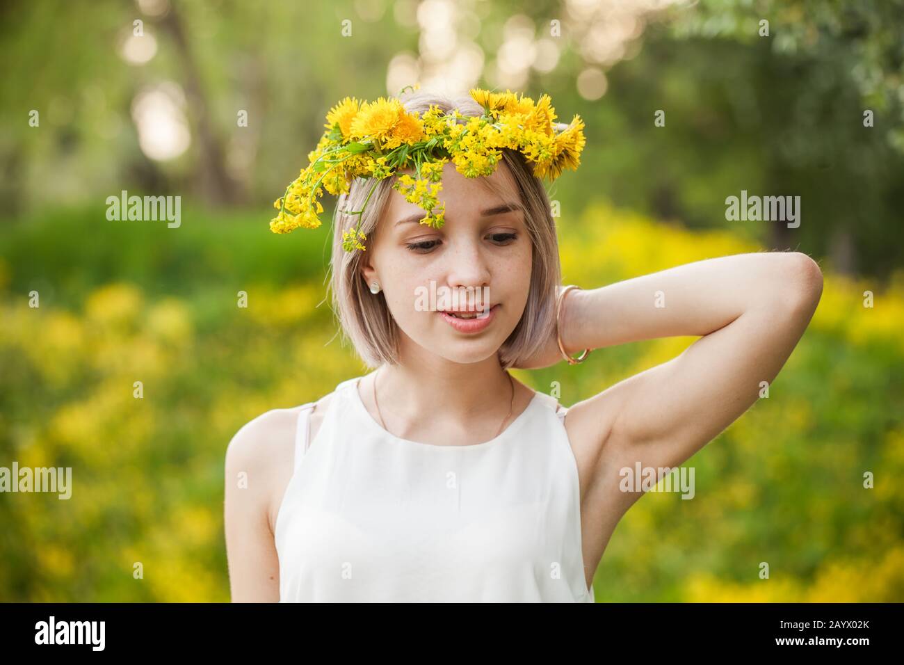 Young beautiful woman wearing dandelion flowers wreath in spring ...
