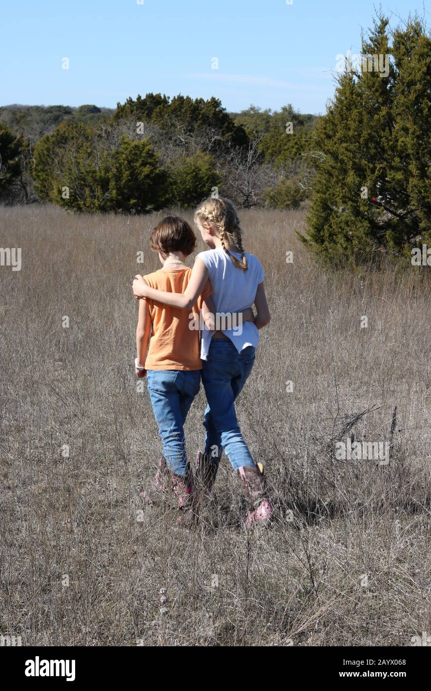 Two girls walking in nature with their arms around each other Stock ...