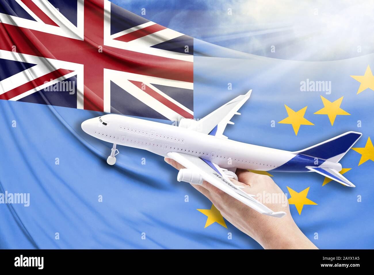 Airplane in hand with national flag of Tuvalu on a background of blue ...