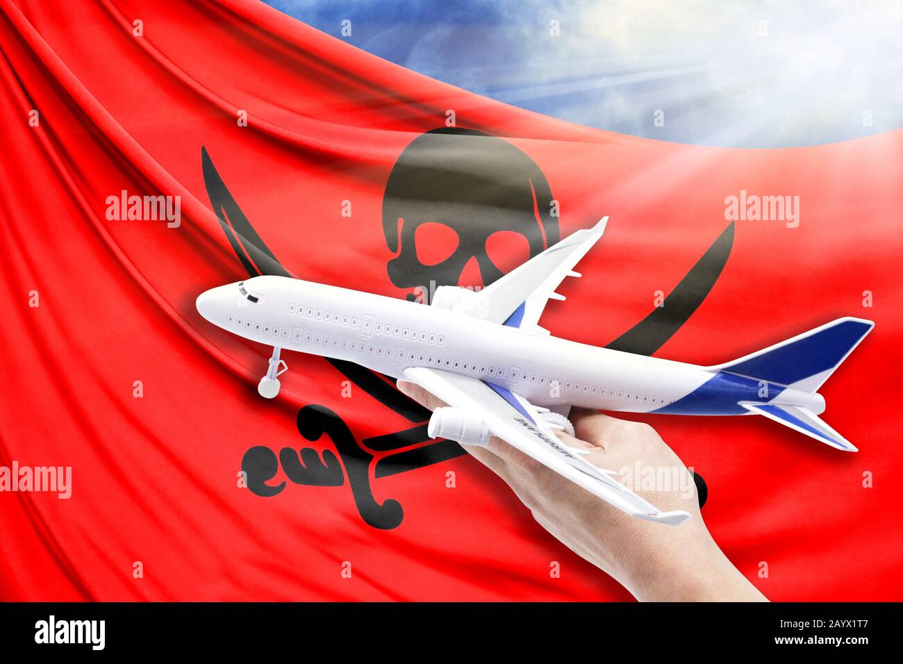 Airplane in hand with national flag of Pirates red on a background of ...