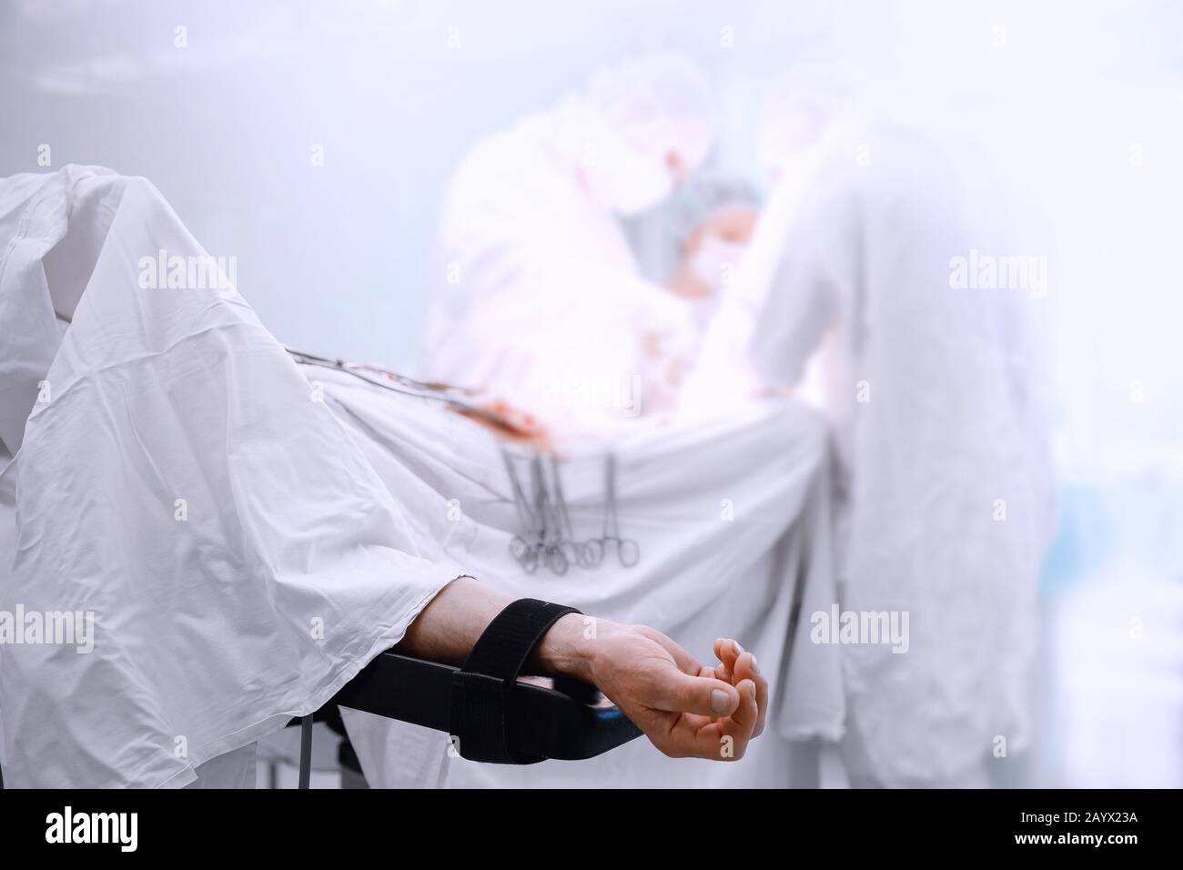 Hand of patient on operating table, doctors are operation person. Light ...