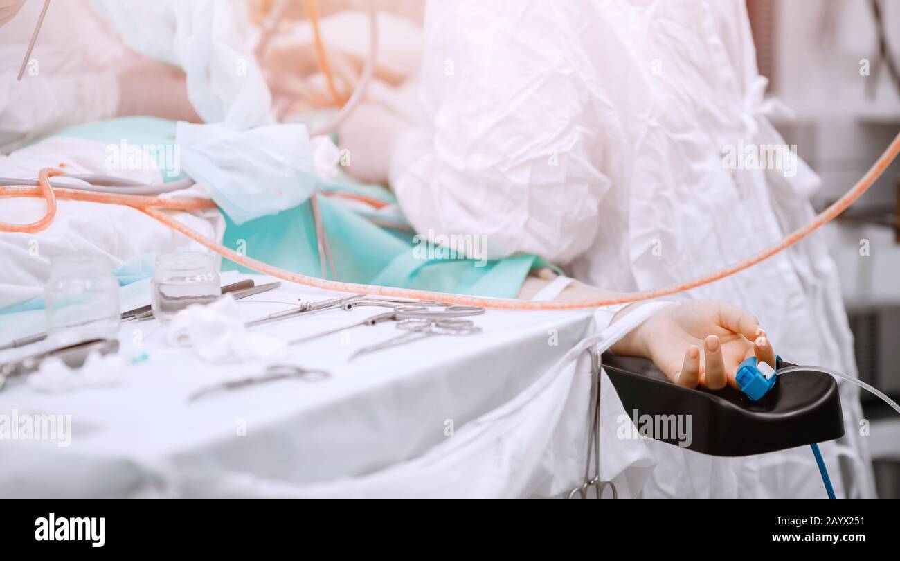 Hand of patient on operating table, doctors are operation person. Light ...