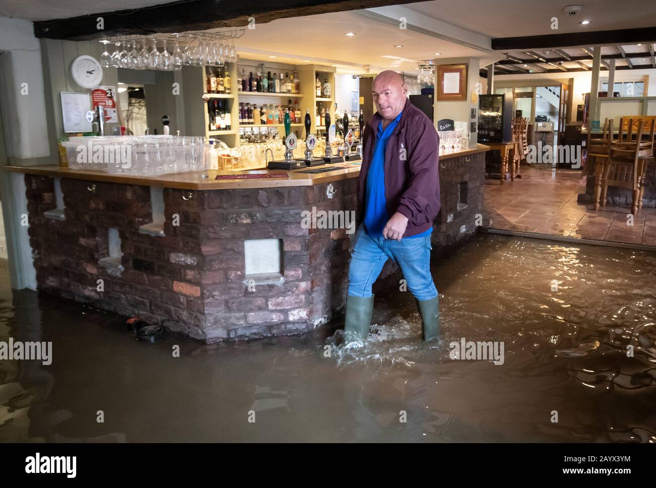 Landlord Colin Reynolds walks through flood water in the Ship Inn in ...