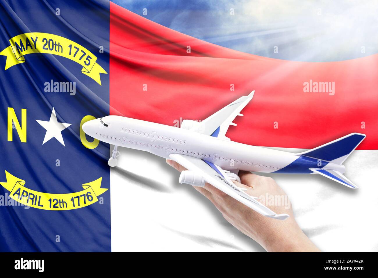Airplane in hand with national flag State of North Carolina on a ...