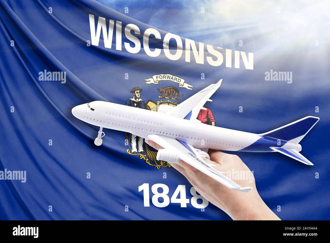 Airplane in hand with national flag State of Wisconsin on a background ...