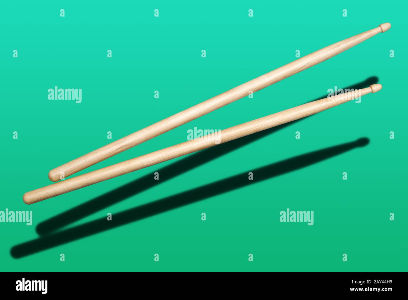 two wooden drumsticks on green background Stock Photo - Alamy