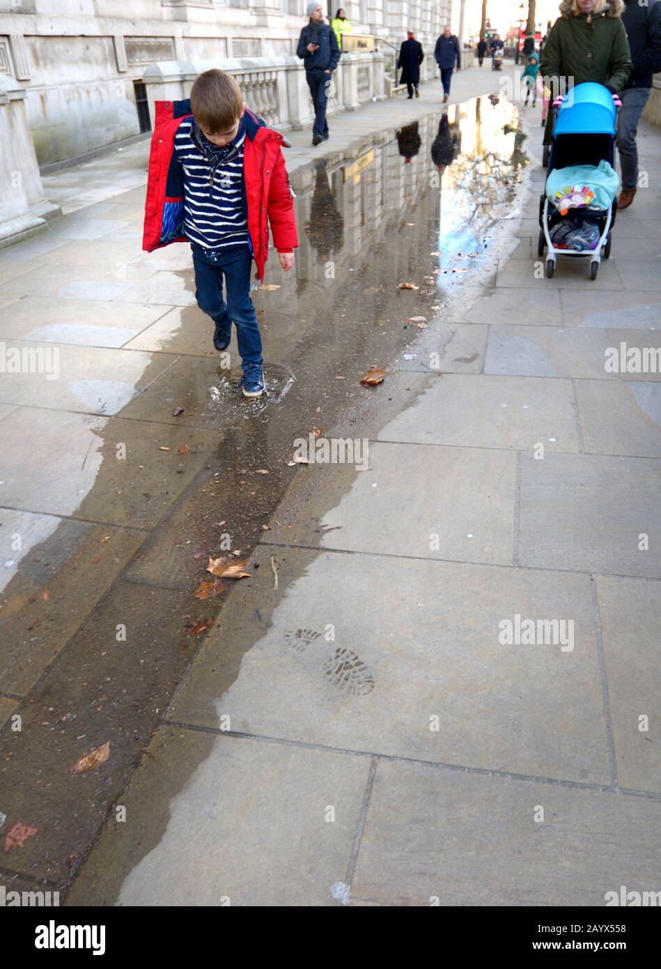 London, England, UK. Young boy playing in a puddle in Whitehall Stock ...