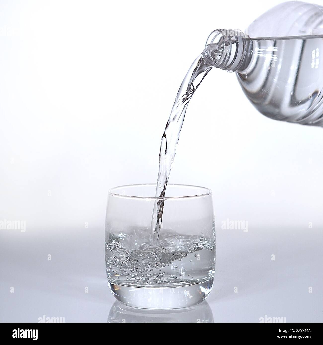 Water being poured into Glass against White Background Stock Photo - Alamy